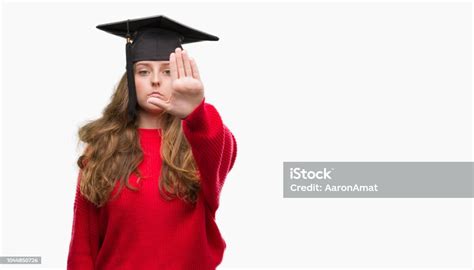 젊은 금발 여 자가 심각 하 고 자신감 표현 방어 제스처 정지 표시를 하 고 오픈 손으로 졸업 모자를 쓰고 경계 표지에 대한 스톡 사진 및 기타 이미지 Istock