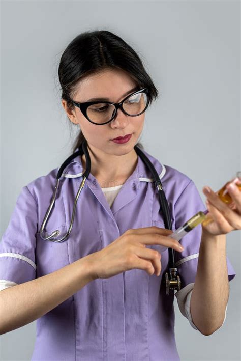 Young Female Nurse Holds A Syringe With A Needle In Her Hand In Medical