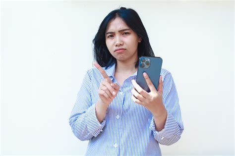슬픈 아시아 여자 들고 스마트 폰 가리키는 손가락 정지 표지판 입고 줄무늬 셔츠 흰색 배경에 고립 된 마음이 산란해진에 대한