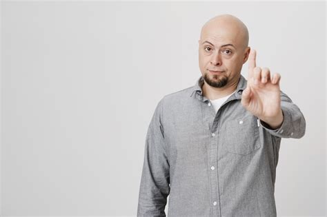 Разочарованный лысый мужчина средних лет трясет пальцем ругает или