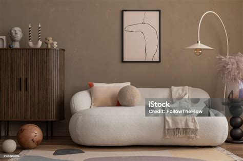 모형 포스터 프레임 부클 소파 나무 찬장 커피 테이블 대리석 램프 갈색 벽 및 개인 액세서리가 있는 미적 거실 인테리어의 창의적인 구성 가정 장식 템플렛 0명에 대한 스톡