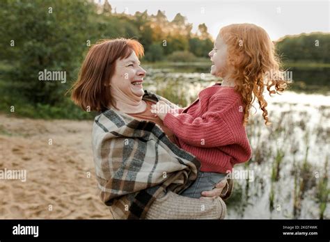 Happy Grandmother Playing With Granddaughter By Lake Stock Photo Alamy