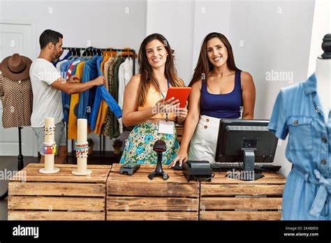 Young Hispanic Shopkeepers Smiling Happy Working Using Touchpad At