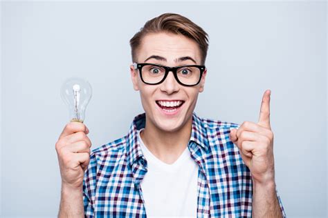 내가 그것을 작동 하는 방법을 알고 닫기 램프 손에 잡고 밝은 매력적인 남자의 초상화 및 집게 봐 밝은 파란색 회색 배경에 고립 된 카메라를 제기 가리키기에 대한 스톡 사진