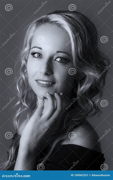Красивая белокурая женщина в вьющиеся волосы и черной верхней части на сером Backgr Стоковое