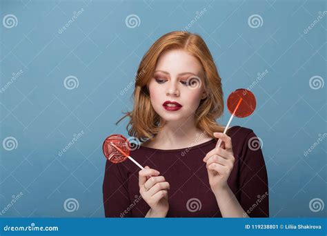 Portrait Of A Young Woman In The Two Candy Canes On A Blue Background