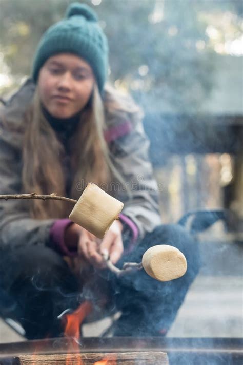 Teenage Girl Wearing Beanie Hat Roasting Large Marshmallow On A Stick