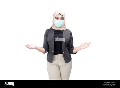 Asian Muslim Woman In A Headscarf And Wearing A Face Mask Standing With