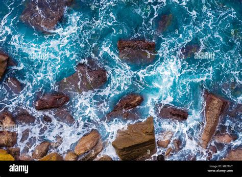 Top Aerial View Of Blue Waves Crashing On Rocky Australian Coastline
