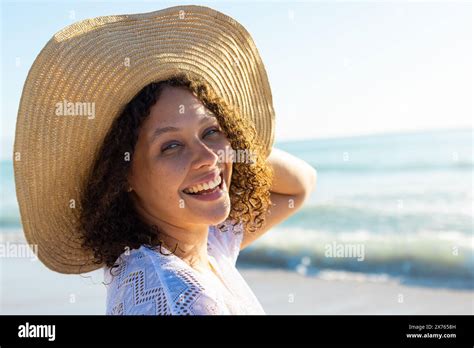 At Beach Biracial Young Woman Wearing Wide Brimmed Hat Smiling Stock