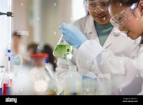Girl Babes Conducting Scientific Experiment Examining Liquid In Beaker In Laboratory