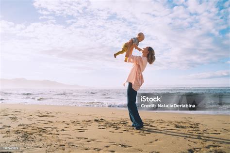 해변 바다에서 함께 놀고 즐기는 작은 아이를 가진 어머니 야외에서 행복한 가족 자연에서 여름에 엄마와 아기 긍정적 인 인간의