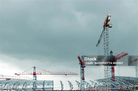 건설 현장 배경에서 미완성 높은 상승 건물과 푸른 하늘을 가진 큰 산업 타워 크레인 비 계 현대 토목 공학 현대 도시 풍경입니다