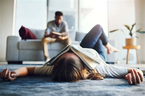 번아웃 피곤하고 공부하고 읽고 프로젝트를 진행한 후 바닥에 누워 있는 얼굴에 책을 쓴 학생 교육 대학 및 여자는 거실에서