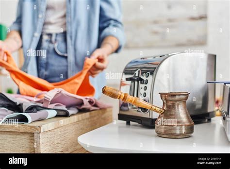Partial View Of Young Woman Sorting Clothes Near Electric Toaster And