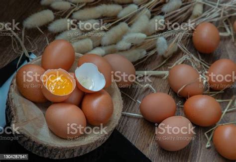 검은 바닥에 작은 목재와 말린 꽃에 배치 신선한 닭 계란 위에 깨진 닭 계란 갈색에 대한 스톡 사진 및 기타 이미지 갈색