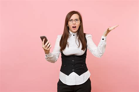 젊은은 비즈니스 우먼 셔츠 검은 양복 안경 손에 분홍색 배경에 절연을 확산 하는 휴대 전화를 들고에 우려 여자 보스입니다 성과
