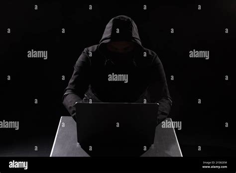 Cyber Hacker In Hood Behind Laptop In Dark Room Digital Cyber Security Concept Computer