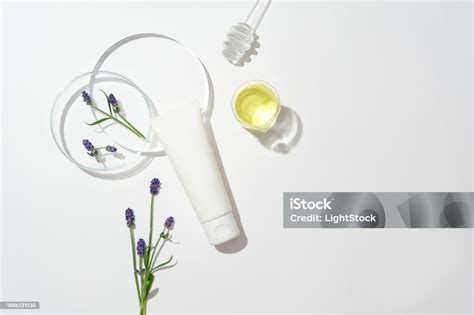 유리 제품과 신선한 라벤더 꽃 옆에 놓인 라벨이 없는 화장품 튜브의 위에서 본 모습 텍스트 디자인을 위한 빈 공간 흰색 배경의