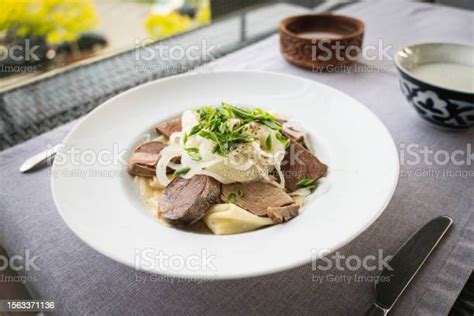 맛있는 카자흐스탄 국민 요리 Beshbarmak의 구성 Kazy 밀가루 또띠아 식당의 테이블에 양파와 함께 접시에 국가 관광