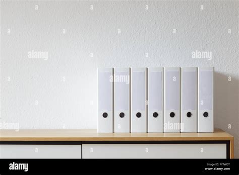 White File Folders On Wooden Sideboard In Modern Bright Office Stock