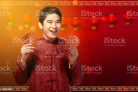 그의 손에 Angpao를 보여주는 전통 옷을 입고 매력적인 중국 남자 개념에 대한 스톡 사진 및 기타 이미지 개념 공휴일