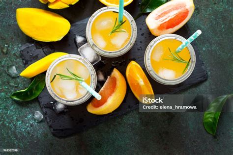 신선한 상쾌한 여름 음료 감귤 류와 얼음 망고 스무디 어두운 돌 배경에 Multifruit 음료 공간 최고의 복사 평면 위치