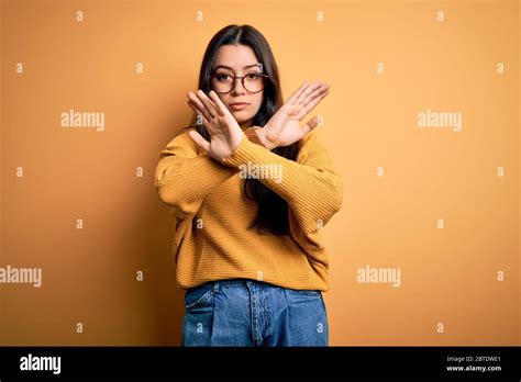 Young Brunette Woman Wearing Glasses And Casual Sweater Over Yellow