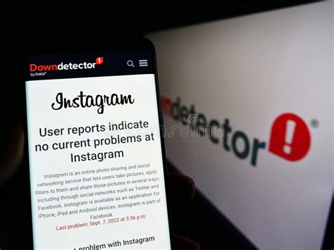 Person Holding Smartphone With Website Of Platform Downdetector And