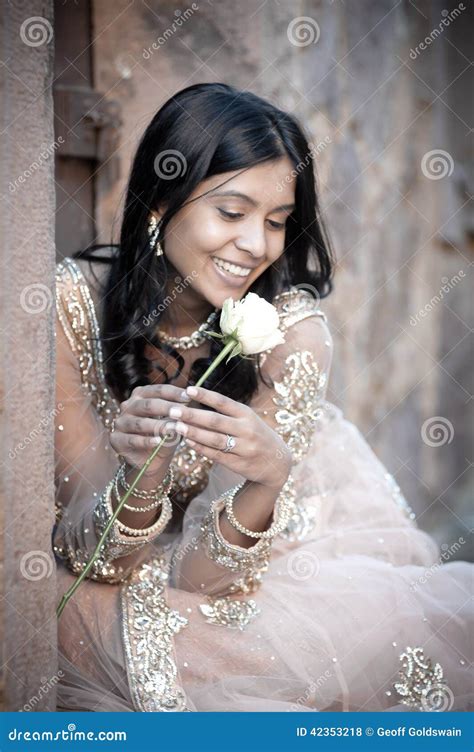 Junge Schöne Indische Frau Die Draußen Gegen Steinwand Sitzt Stockfoto