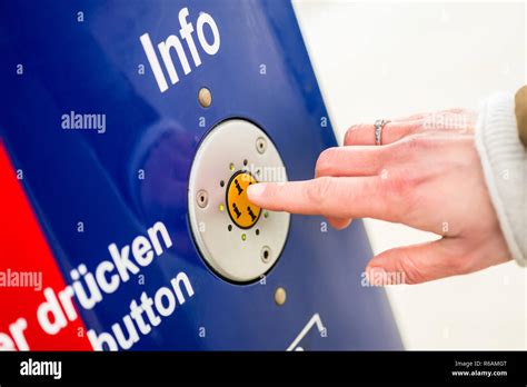 Woman Pressing Info Button Of Assistance Machine In Train Station Stock