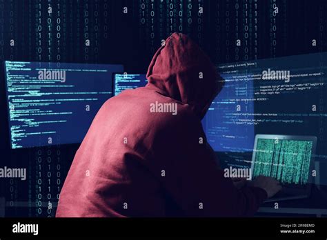 cyber attack anonymous hacker working with laptop and monitors on dark blue background binary