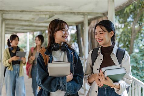 책을 들고 다음 강의실로 걸어가면서 이야기하는 대학생들 2명에 대한 스톡 사진 및 기타 이미지 2명 Group A 공부