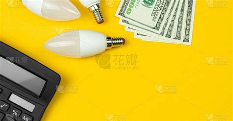计算房屋能效计算器LED灯泡和钱节能的概念黄色背景平铺照片