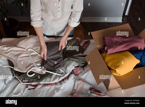 woman is sorting through her clothes folding and packing unwanted