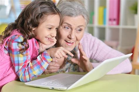 Portrait Of Grandmother And Granddaughter Using Modern Laptop Stock Photo Image Of Grandmother