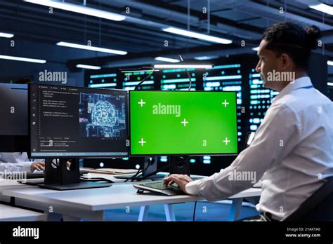 System Administrator Doing Checkup On Green Screen Computer In Server Hub Used For Artificial