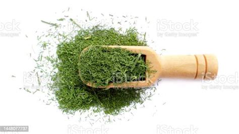 흰색 배경에 격리된 나무 숟가락이 있는 마른 딜 더미 상위 뷰 흰색 배경에 격리된 마른 딜과 나무 숟가락의 힙 흰색 배경에 녹색