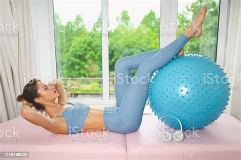 근육 슬림 매력적인 여성 평평한 배 완벽 한 몸 아름다운 맞는 여자는 창 앞에서 집에서 피트니스 필라테스 블루 볼요가 운동을하고 액티브 건강 스포티한 라이프 컨셉 건강한