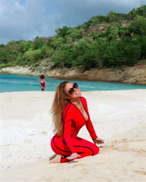 Mariah Carey Is Peak Mariah Carey While Posing On A Beach In A Red Full