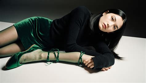 A Woman With Long Black Hair Is Laying On Her Stomach On A Long Table