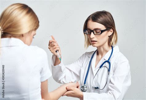 Female Doctor Giving An Injection To A Scared Female Patient In A White