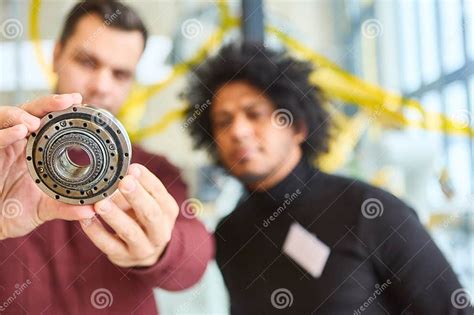 Engineers Examining Robotic Component For Industrial Automation In Technology Lab Stock Image