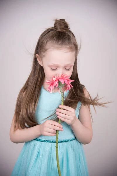 Chica oliendo una flor fotos de stock imágenes de Chica oliendo una