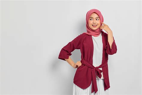 캐주얼 셔츠를 입은 쾌활한 아름다운 아시아 여성이 엉덩이에 손을 얹고 흰색 배경 위에 고립 된 복사 공간을 바라 봅니다 20 24세에 대한 스톡 사진 및 기타 이미지