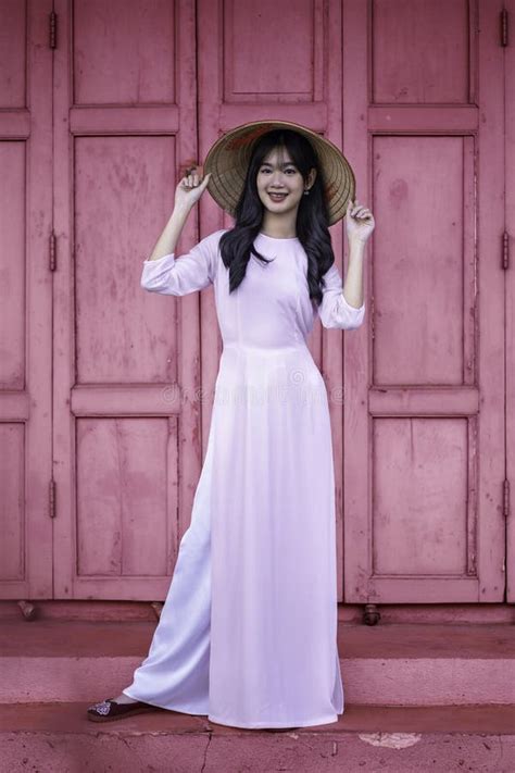 A Beautiful Vietnamese Schoolgirl In A White Pink Ao Dai And Pink Door