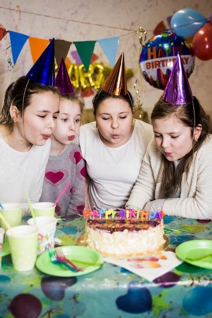 Filles soufflant des bougies sur le gâteau Photo Gratuite