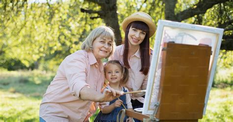 행복한 가족 3 세대 여성 야외에서 가족 그림 귀여운 어린 소녀가 엄마와 할머니와 함께 즐거운 시간을 보내며 봄 정원의 이젤에 그림을 함께 그립니다 사진