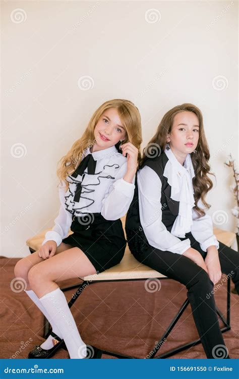 Two Cute Girls Schoolgirls With Long Curly Hair In Fashionable School