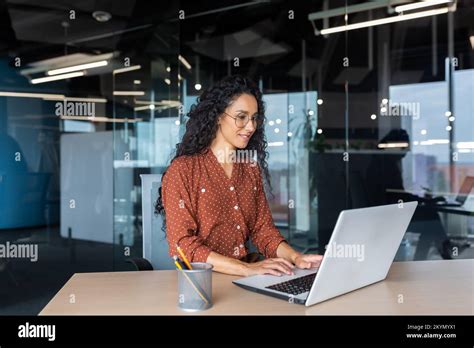 cheerful and successful indian woman programmer at work inside modern